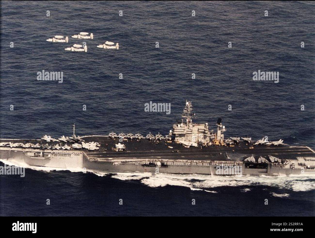 Four Grumman E-2C Hawkeye of VAW-114 in flight over USS Kitty Hawk (CV ...