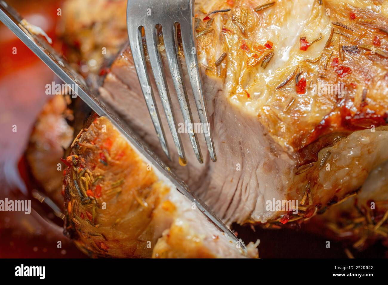 Tender roasted pork with a crispy, herb-seasoned crust is shown in a ...