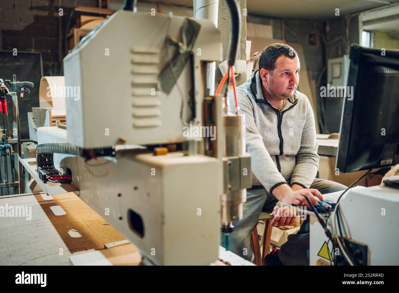 Industrial man worker operating drilling cnc machine at wood machining ...