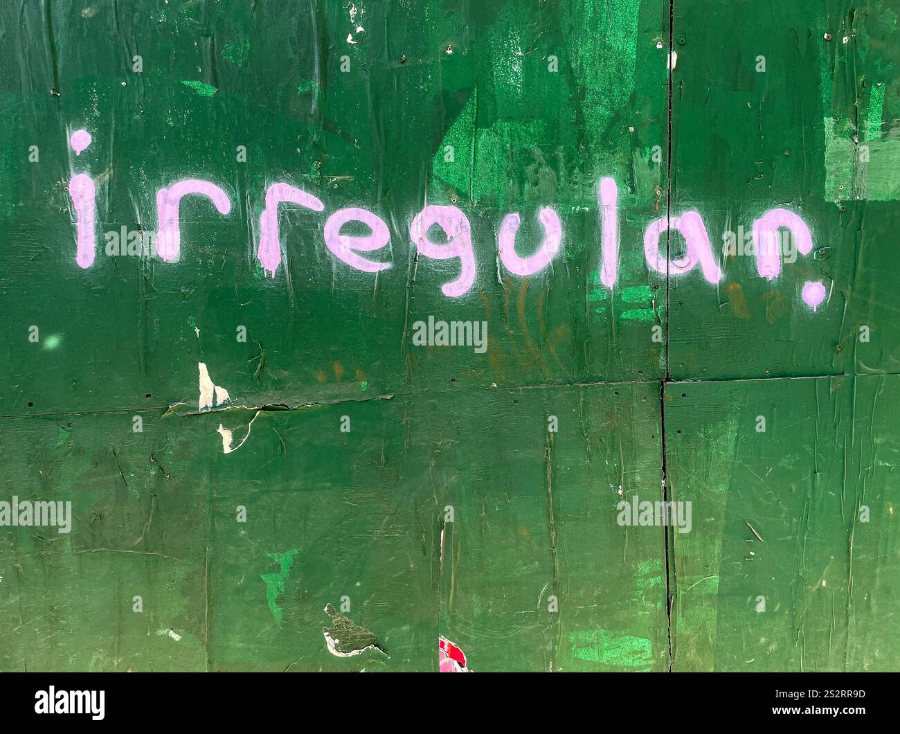 "Irregular" graffiti on green wall Stock Photo - Alamy