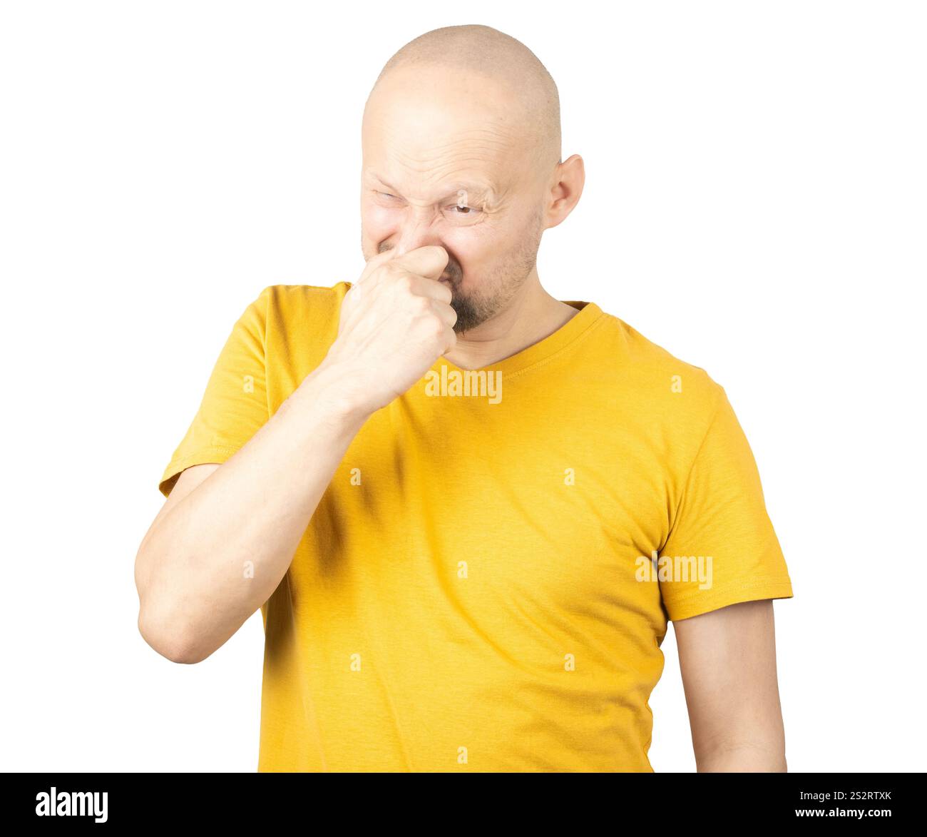 A bald man with a beard is wearing a yellow shirt and pinching his nose ...