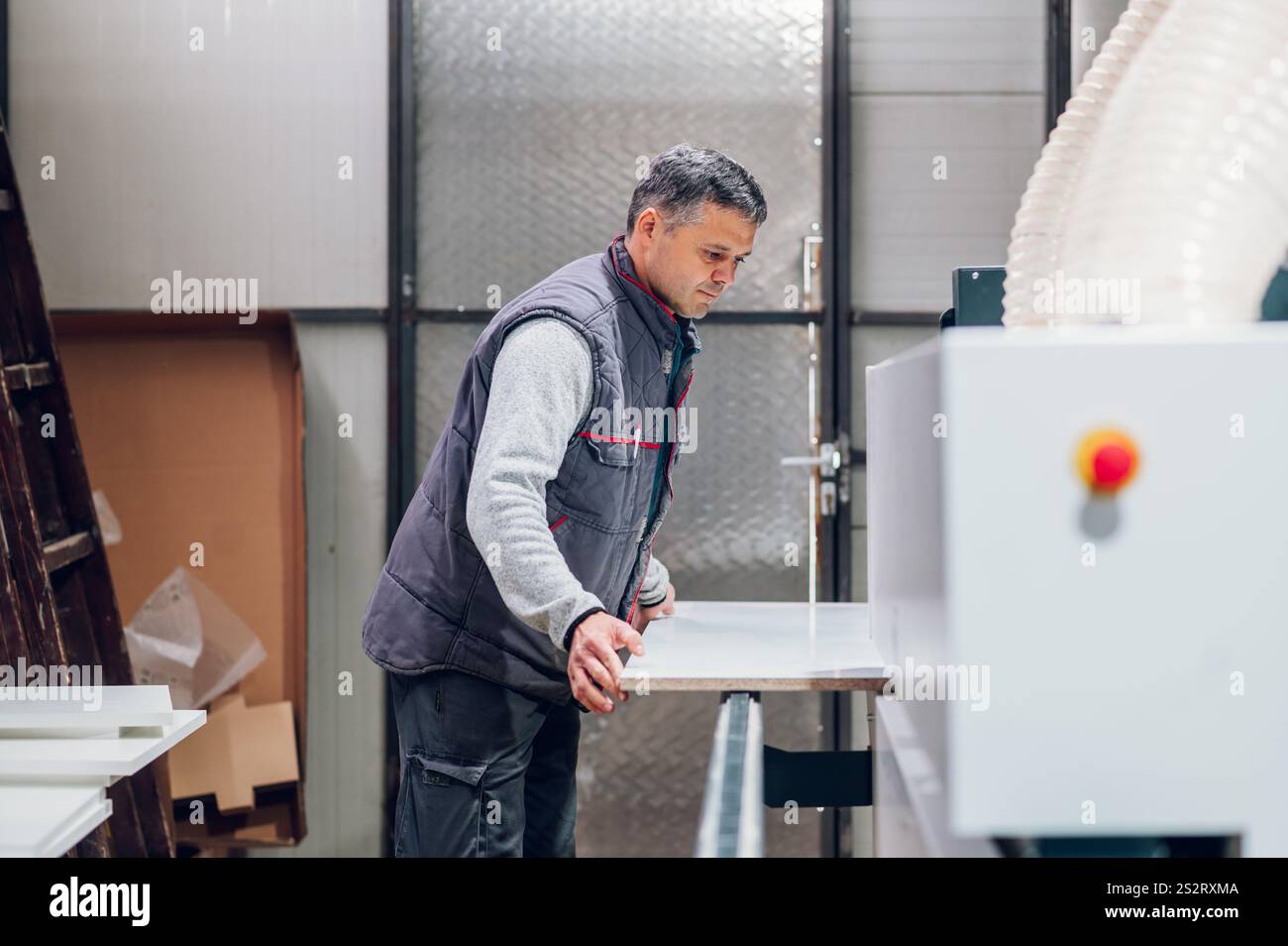 A dedicated carpenter is working with wood processing machine at the ...