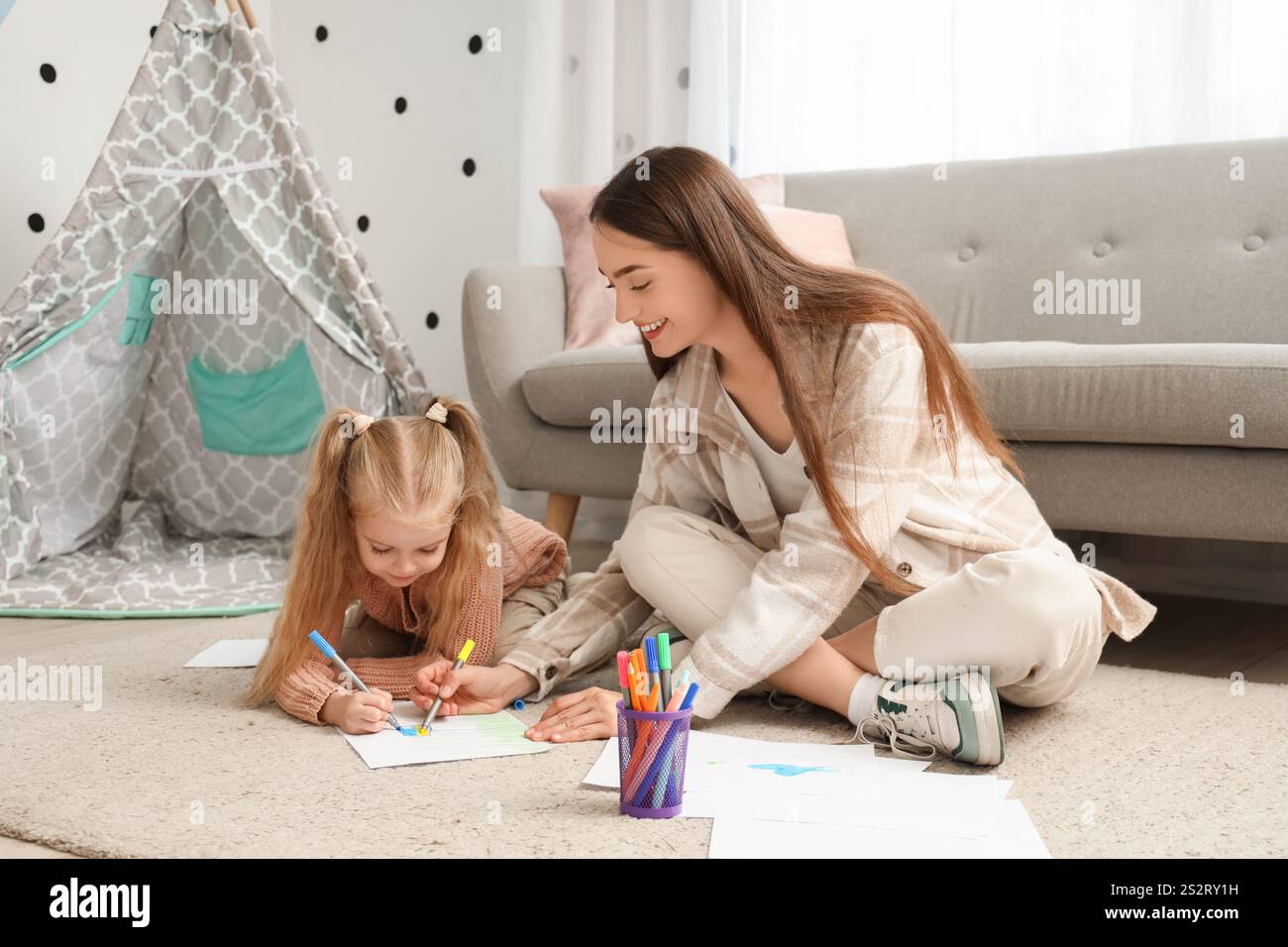 Nanny with cute little girl drawing at home Stock Photo - Alamy