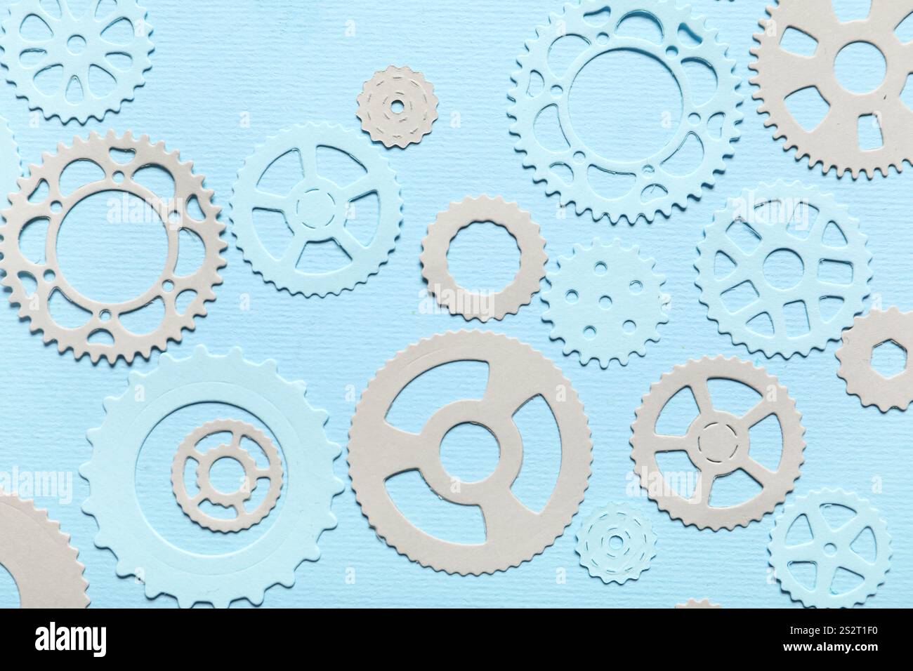Different paper gears on blue background Stock Photo - Alamy