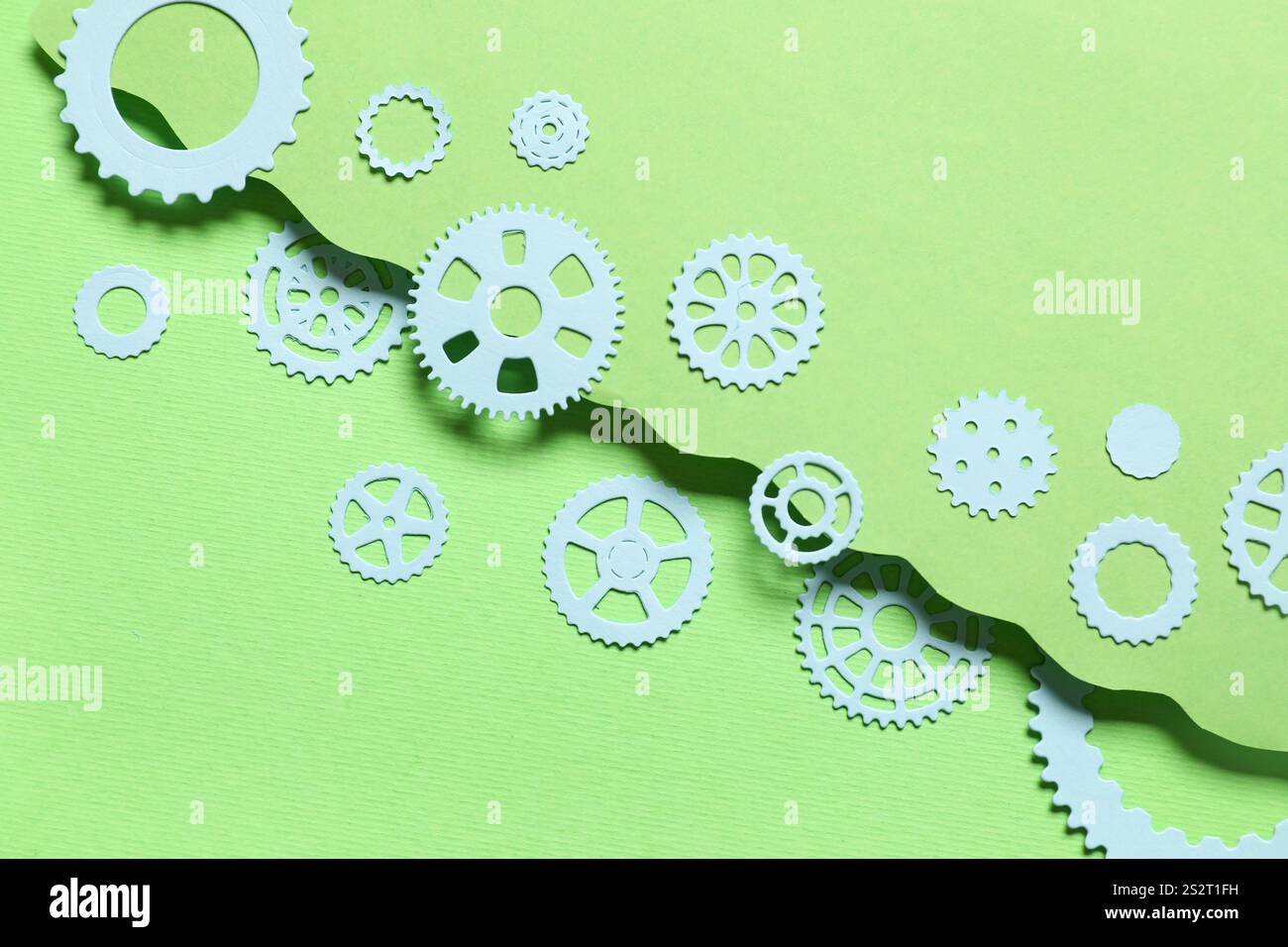 Blue paper gears on green background Stock Photo - Alamy