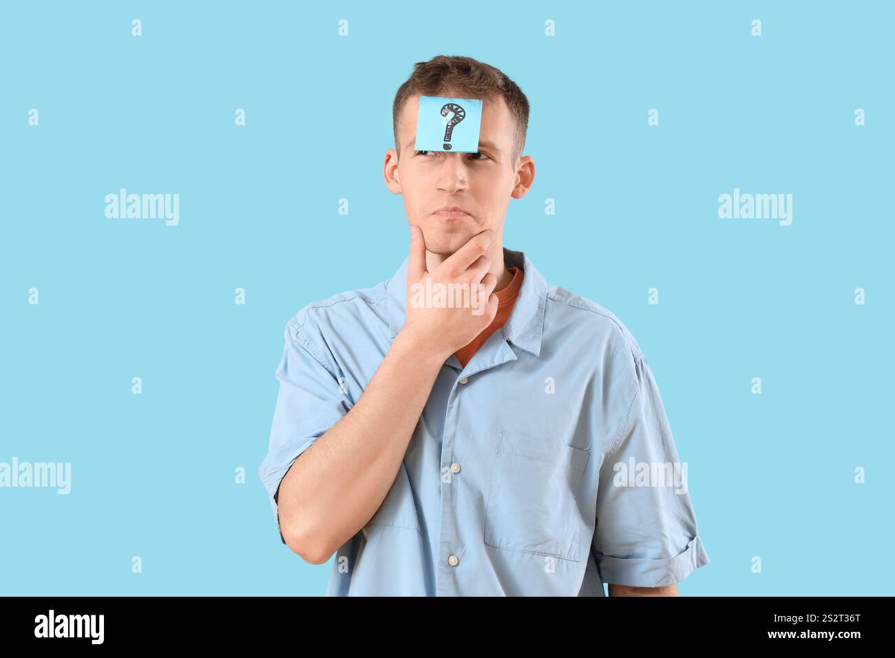 Thoughtful young man and sticky note with question mark on his forehead ...