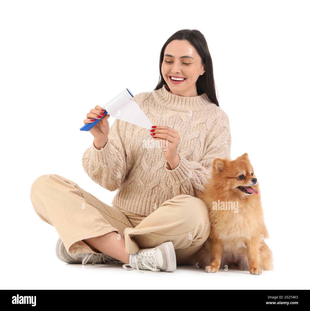Young woman with fluffy dog and lint roller on white background Stock ...