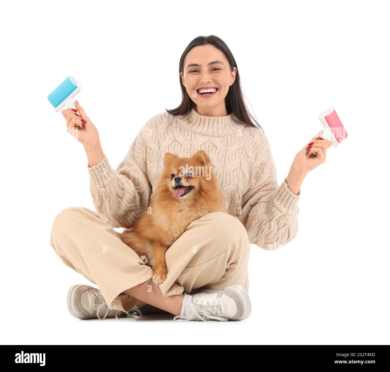 Young woman with fluffy dog and lint rollers on white background Stock ...