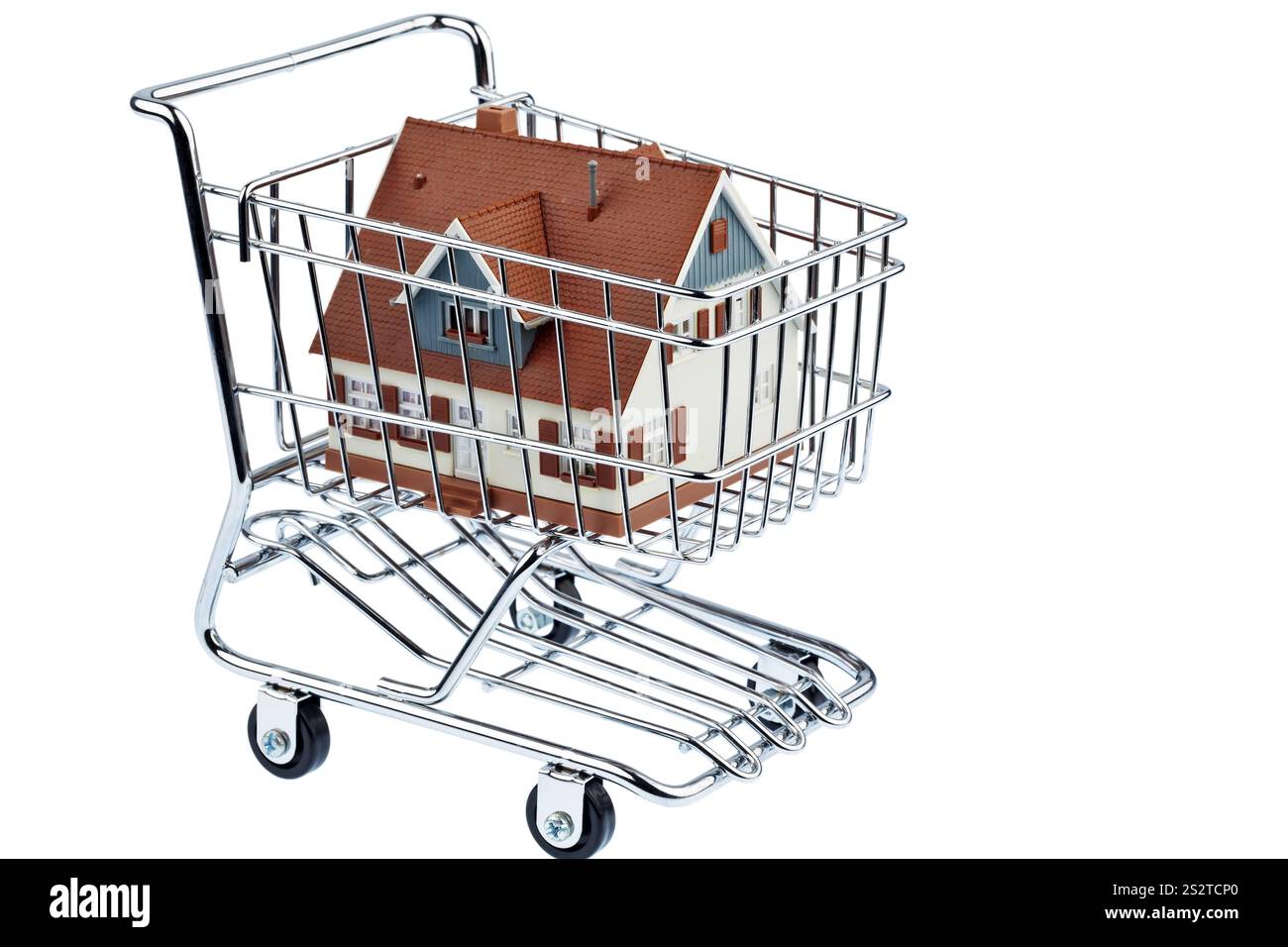 A model of a house in a shopping trolley. Symbol photo for house ...