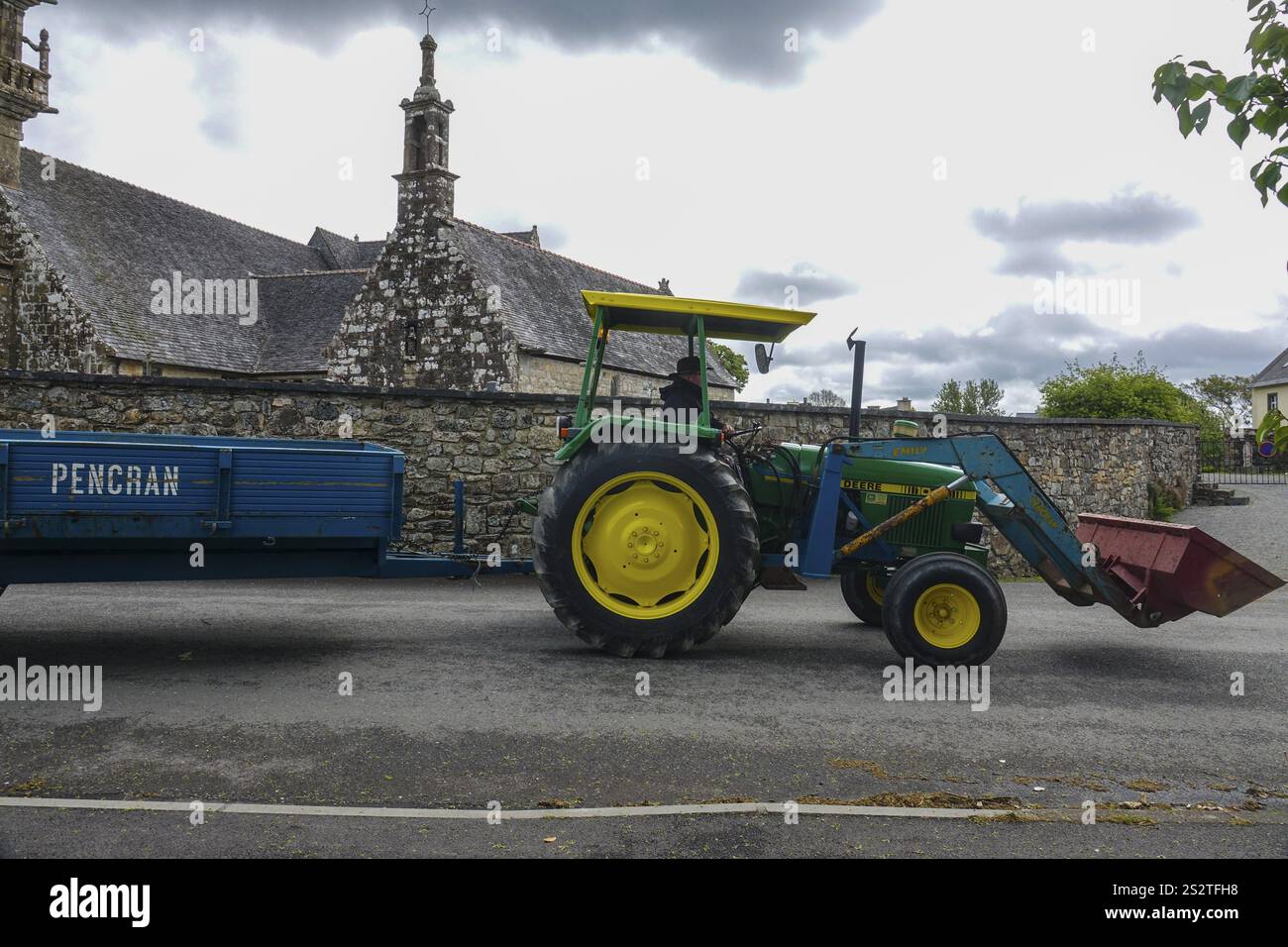 Old tractor John Deere 1040 with trailer in front of church and chapel ...