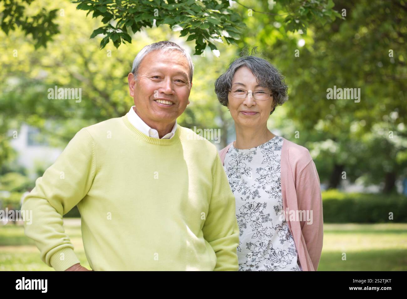 Elderly couple standing side by side in park Stock Photo - Alamy