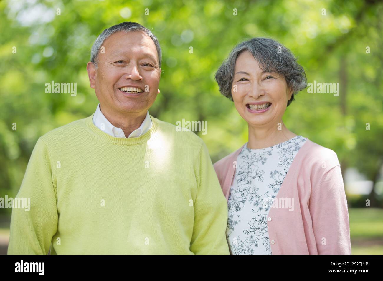 Elderly couple standing side by side in park Stock Photo - Alamy