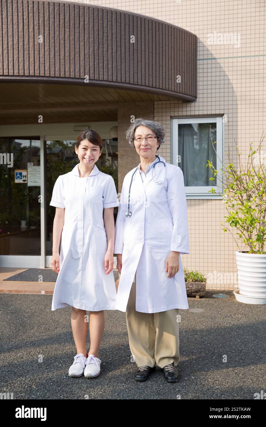 Female doctor and nurse standing in line in front of hospital Stock ...