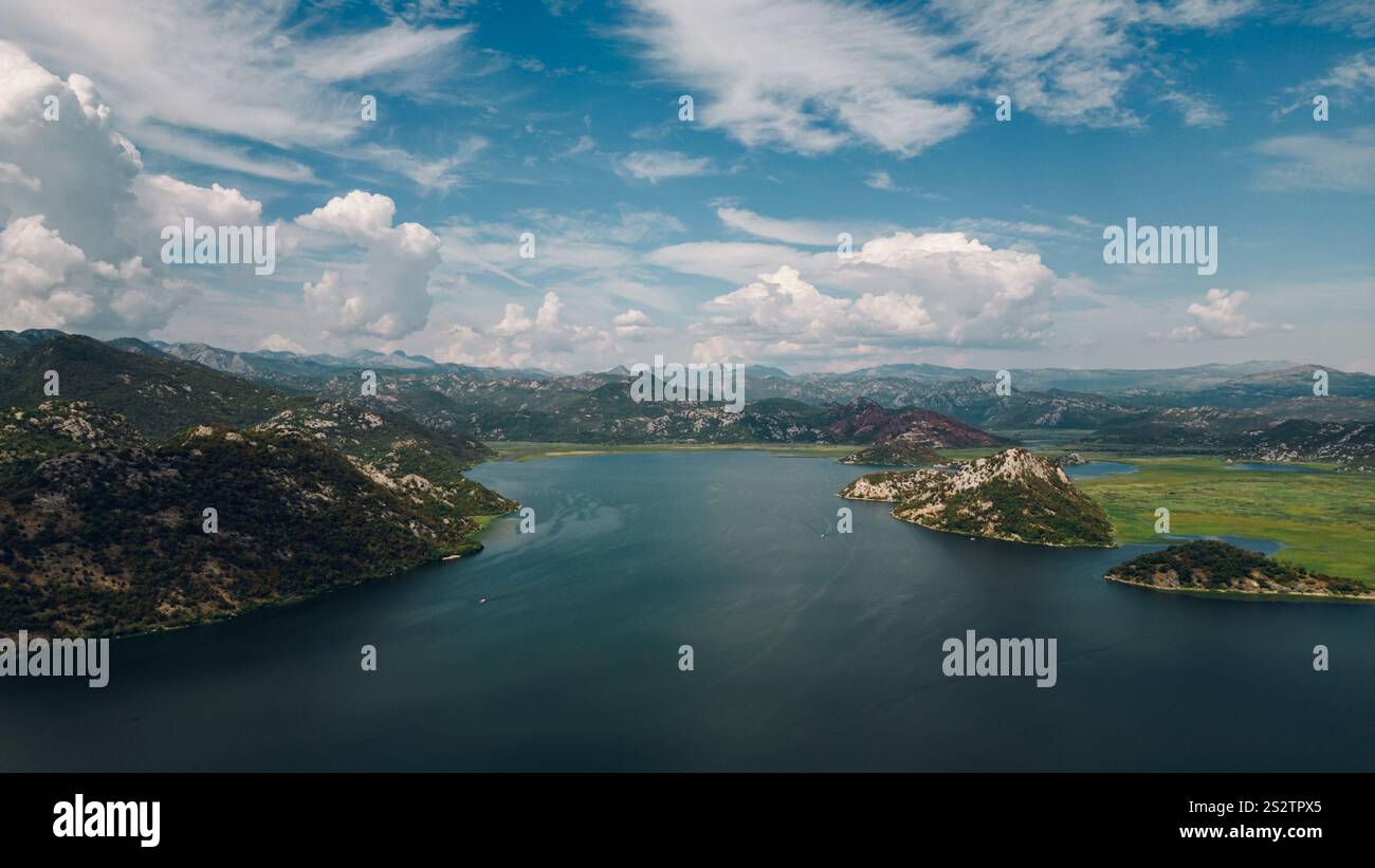 Aerial view of a lake and a nature around it with sky full with clouds ...