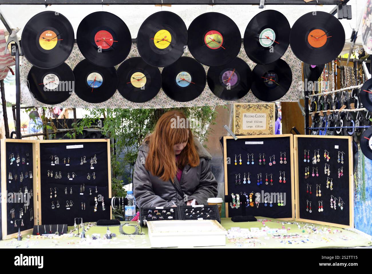 Market stall with handmade jewellery in front of a wall of records ...