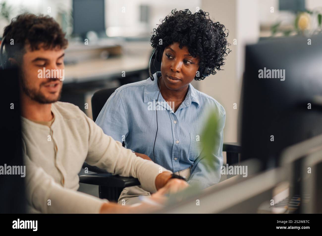 Portrait of an african american woman with headset working in cubicle ...