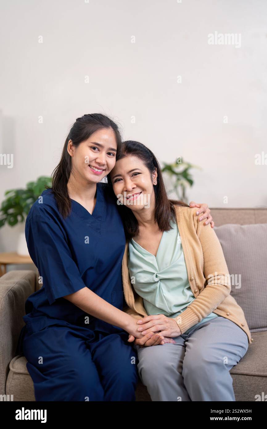 Healthcare professional assisting patient at home comforting ...
