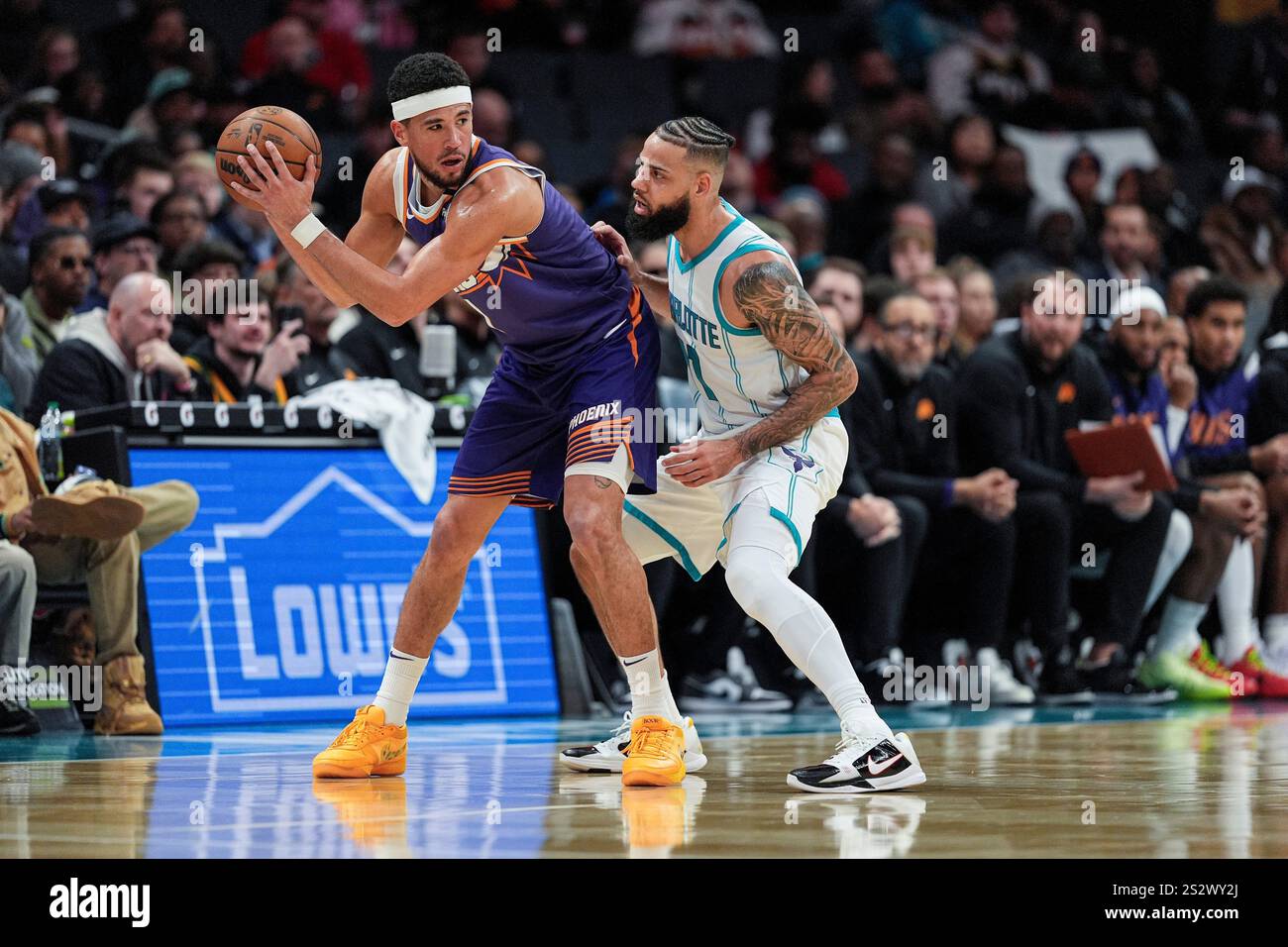 Phoenix Suns guard Devin Booker handles the ball defended by Charlotte ...