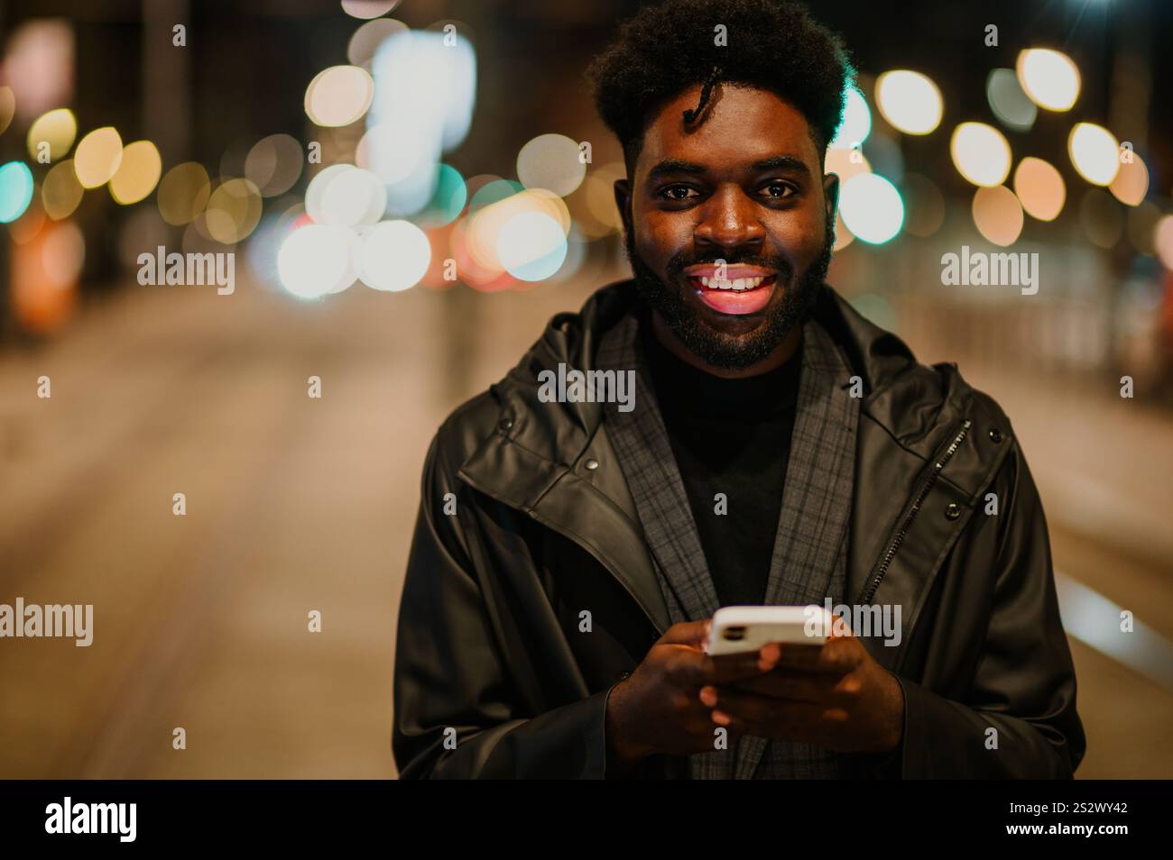 Portrait of an urban African American man standing on the city street ...