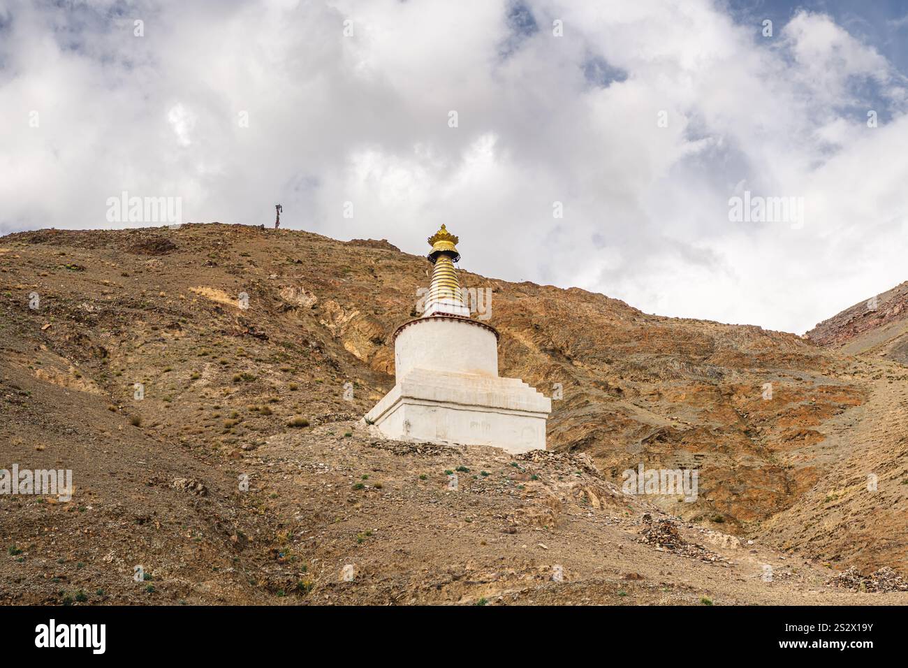 White stupa with golden top and part of the the buddhist Sakya ...