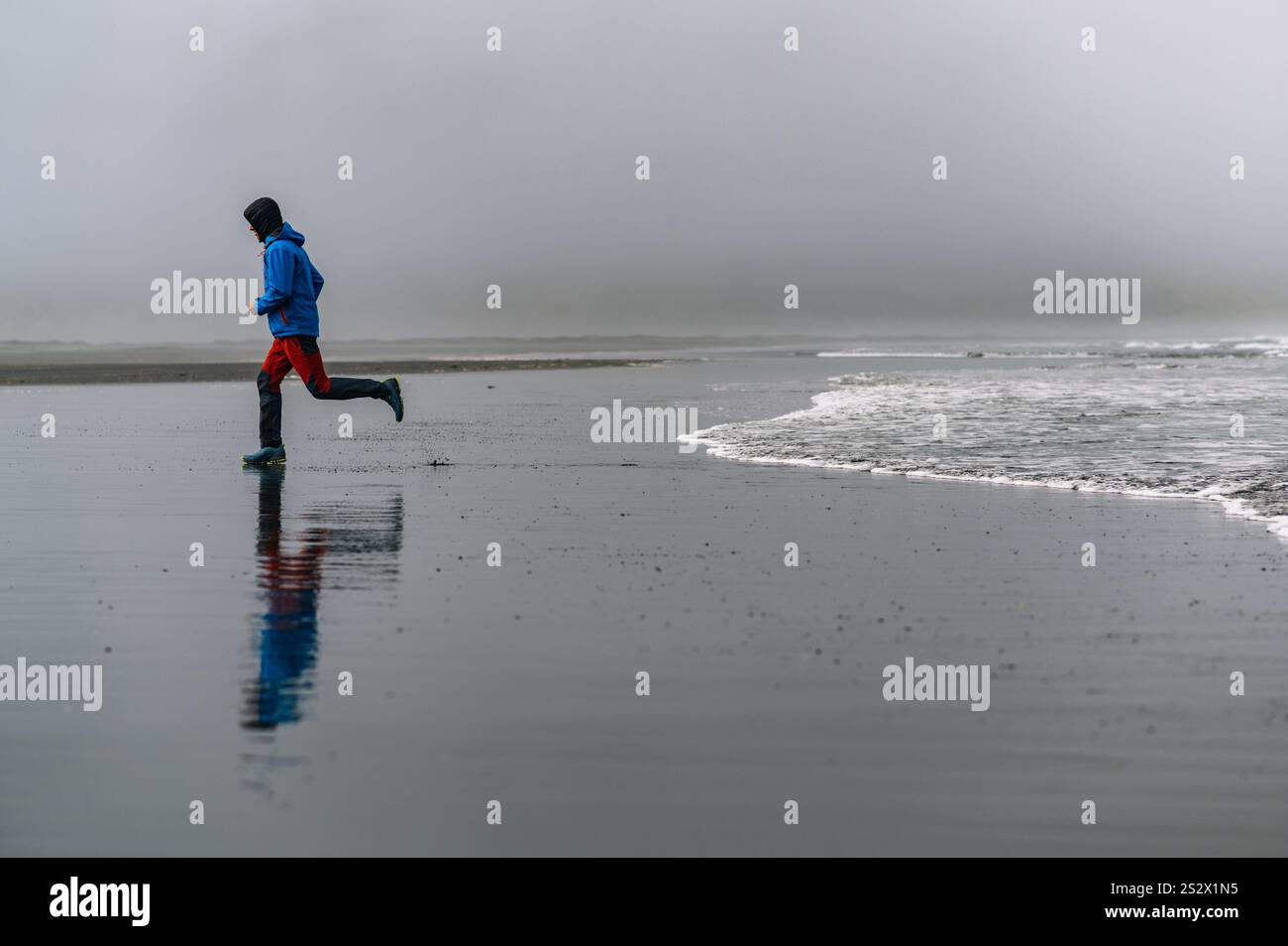 A runner in shape is practicing and running in nature next to the ocean ...