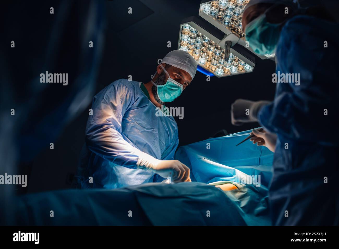 This image shows surgeons deeply engaged in a surgical procedure ...