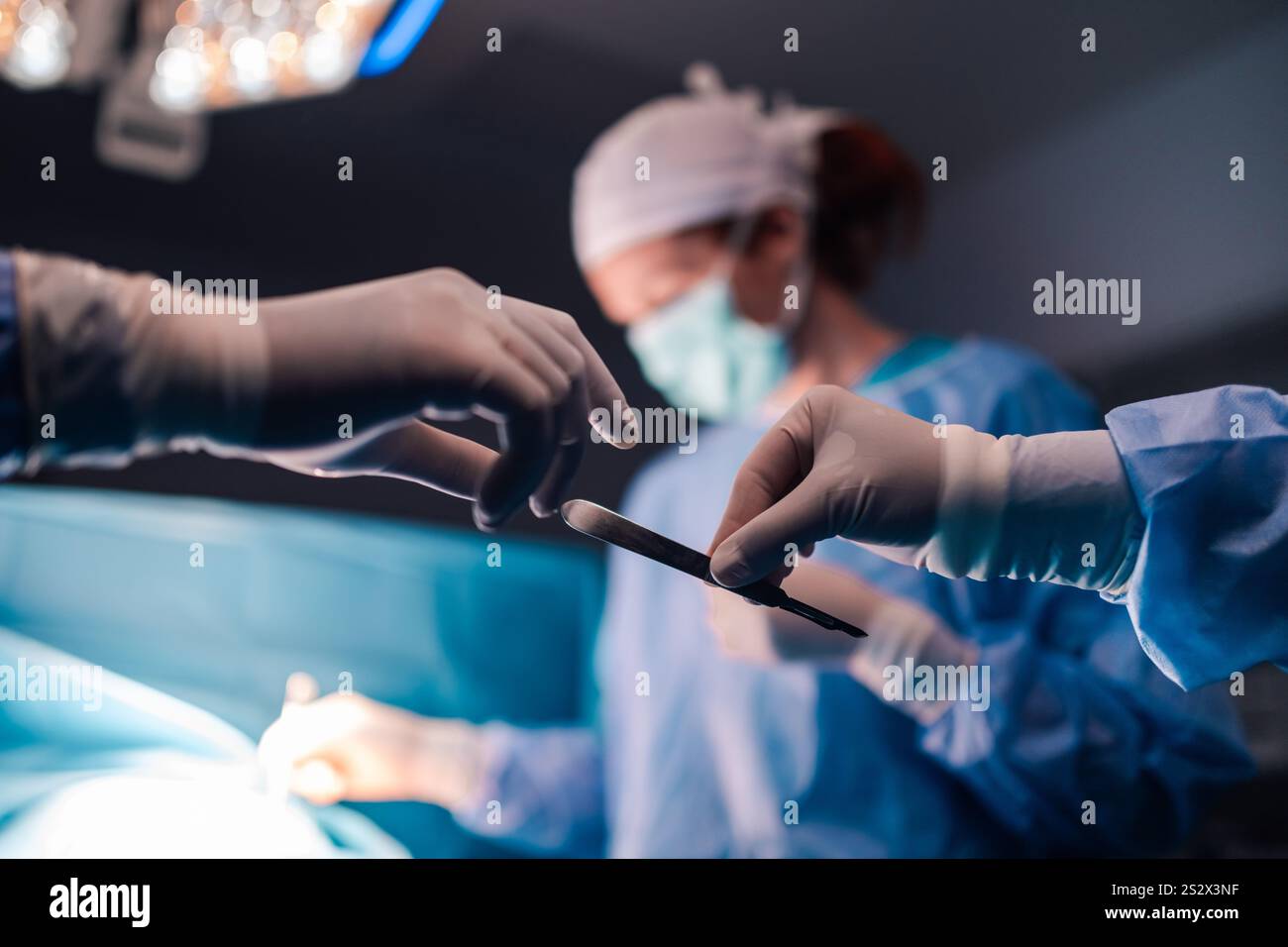 Image captures the moment surgeons pass a medical instrument during a ...