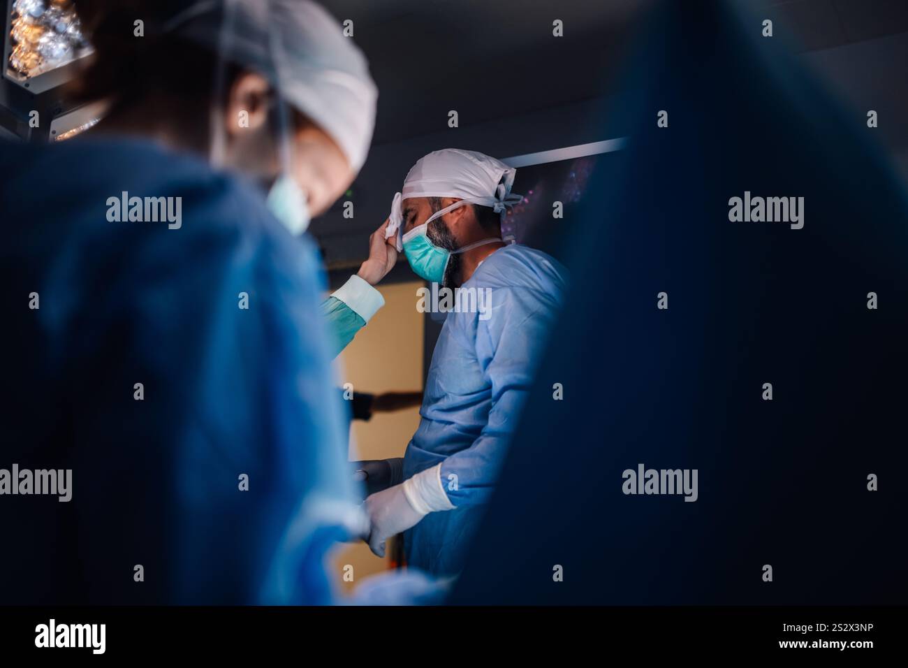 In the midst of an operation, a medical professional adjusts the ...