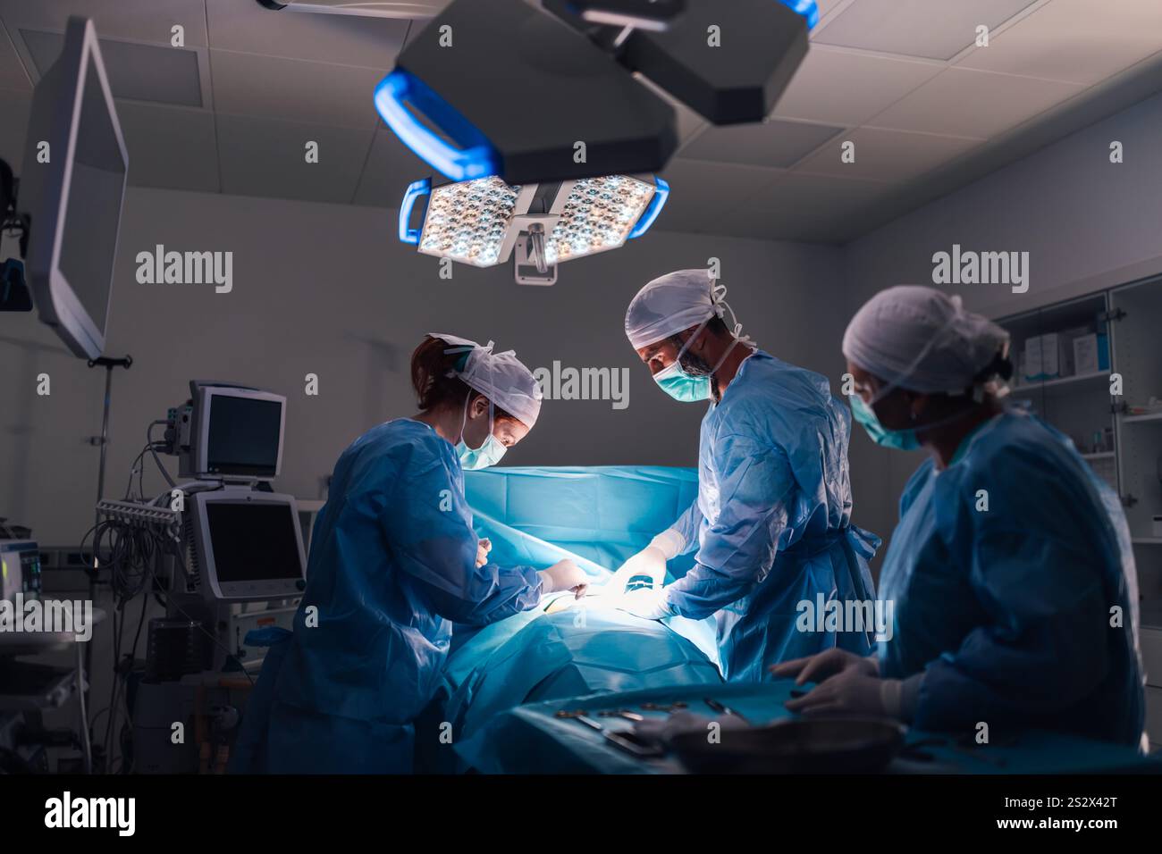 A diligent surgical team conducting an operation under the bright ...