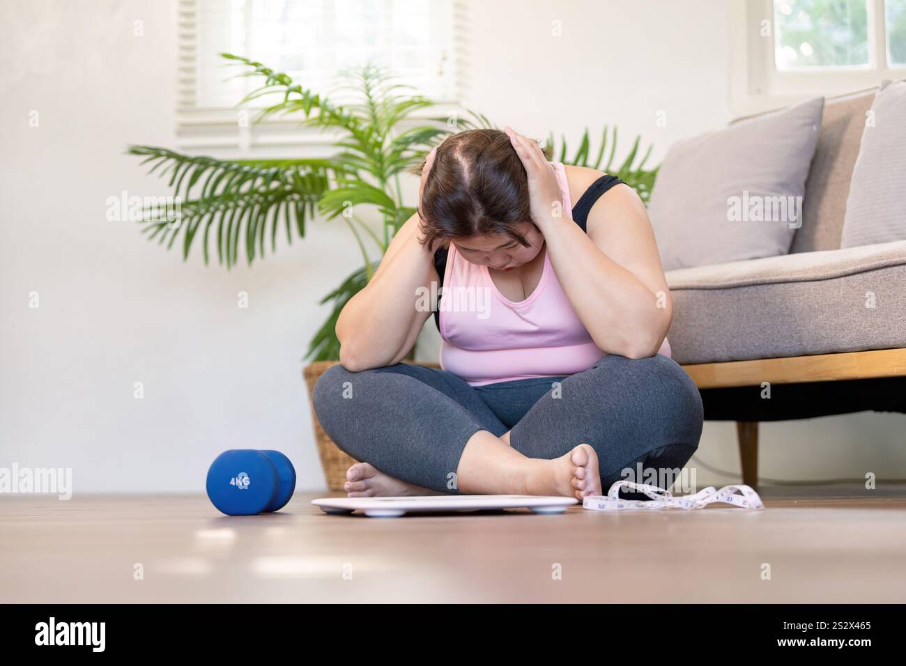 Struggling with weight loss overwhelmed individual on scale in home ...