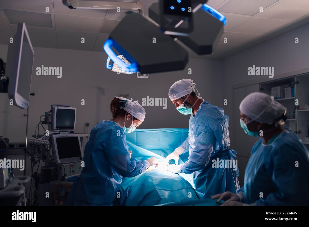 Surgical team in a brightly lit surgery room, performing an operation ...