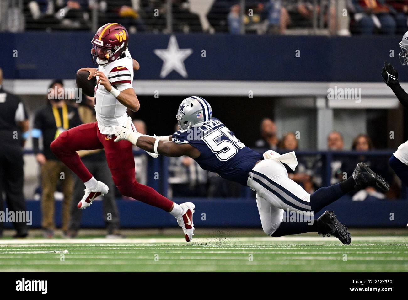 Washington Commanders quarterback Jayden Daniels (5) eludes the tackle ...