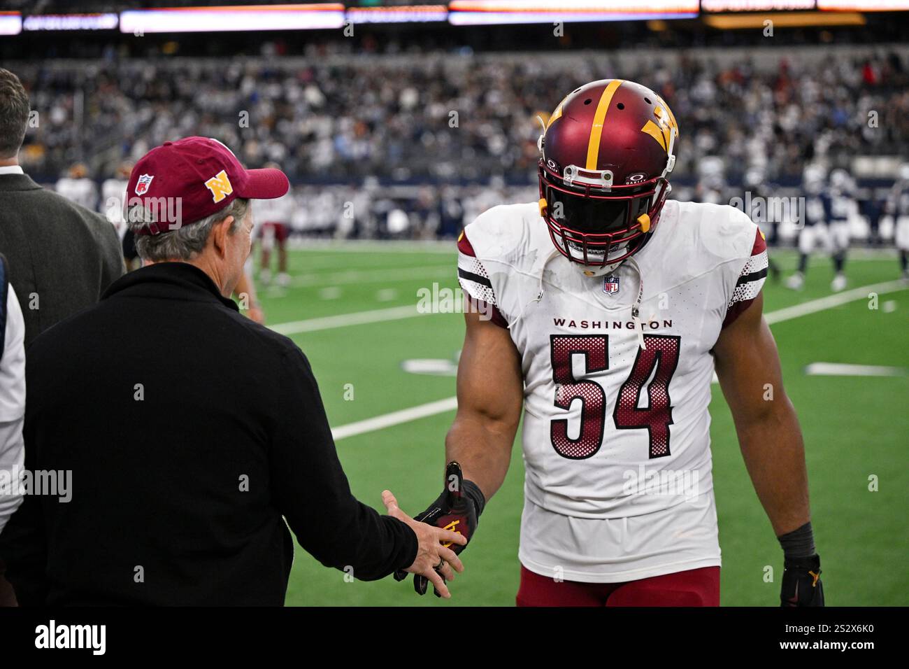 Washington Commanders owner Josh Harris (left) shakes the hand of ...