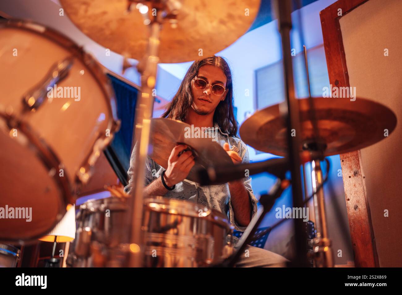 Portrait of a musician man with long hair recording new album in a ...