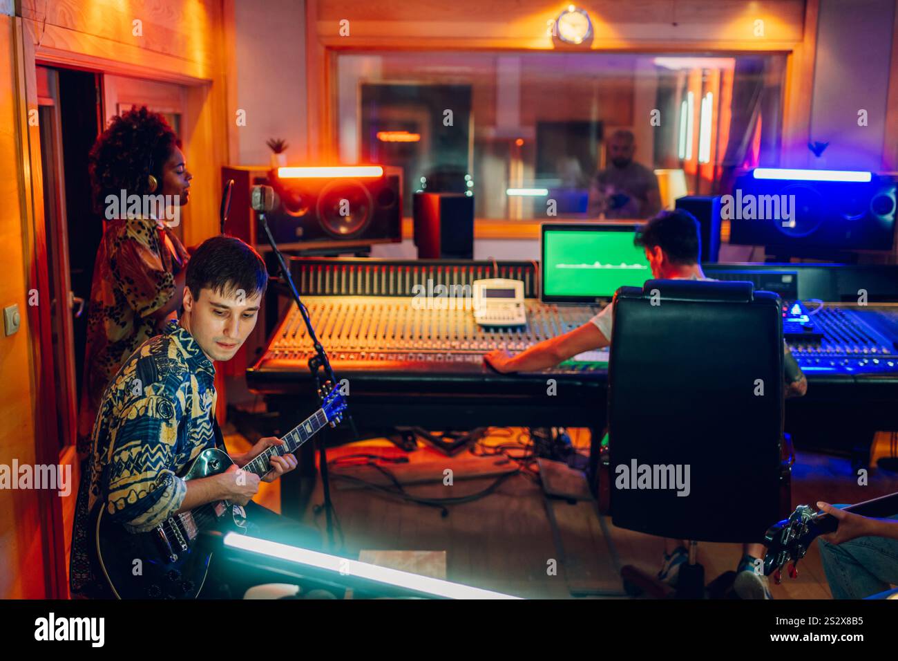 Multicultural band members making song at music recording studio. Cuban ...