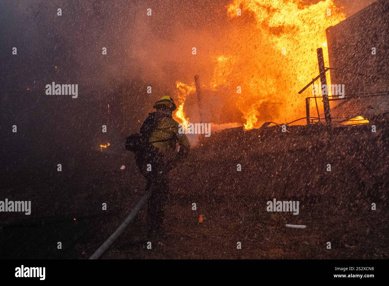 A Cal Firefighter fights the Palisades Fire. Palisades Fire burning ...