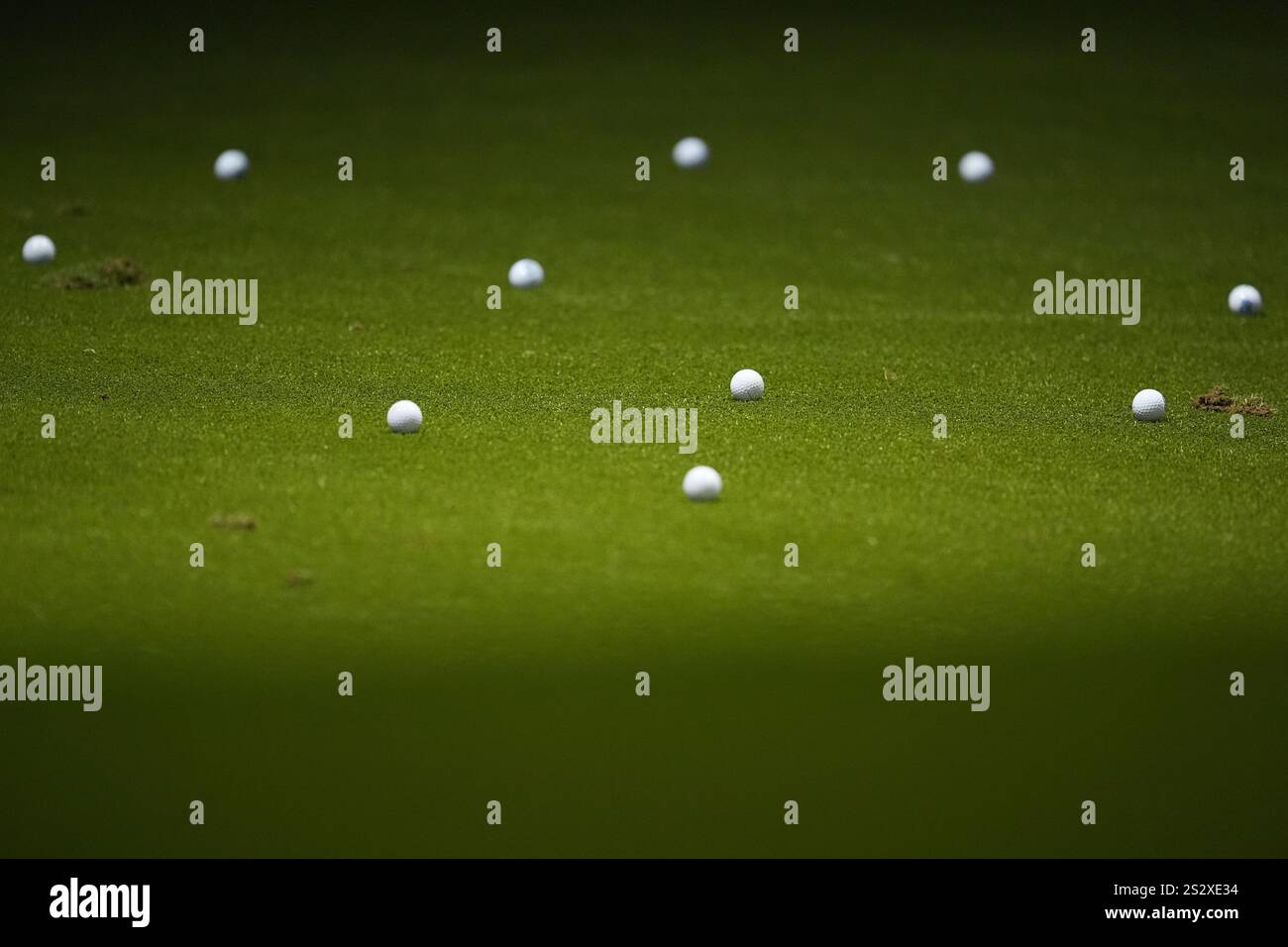Golf balls rest on the ground after being hit into a digital screen ...