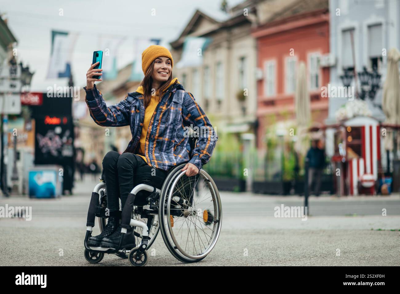 Young beautiful woman with disability who uses a wheelchair taking a ...