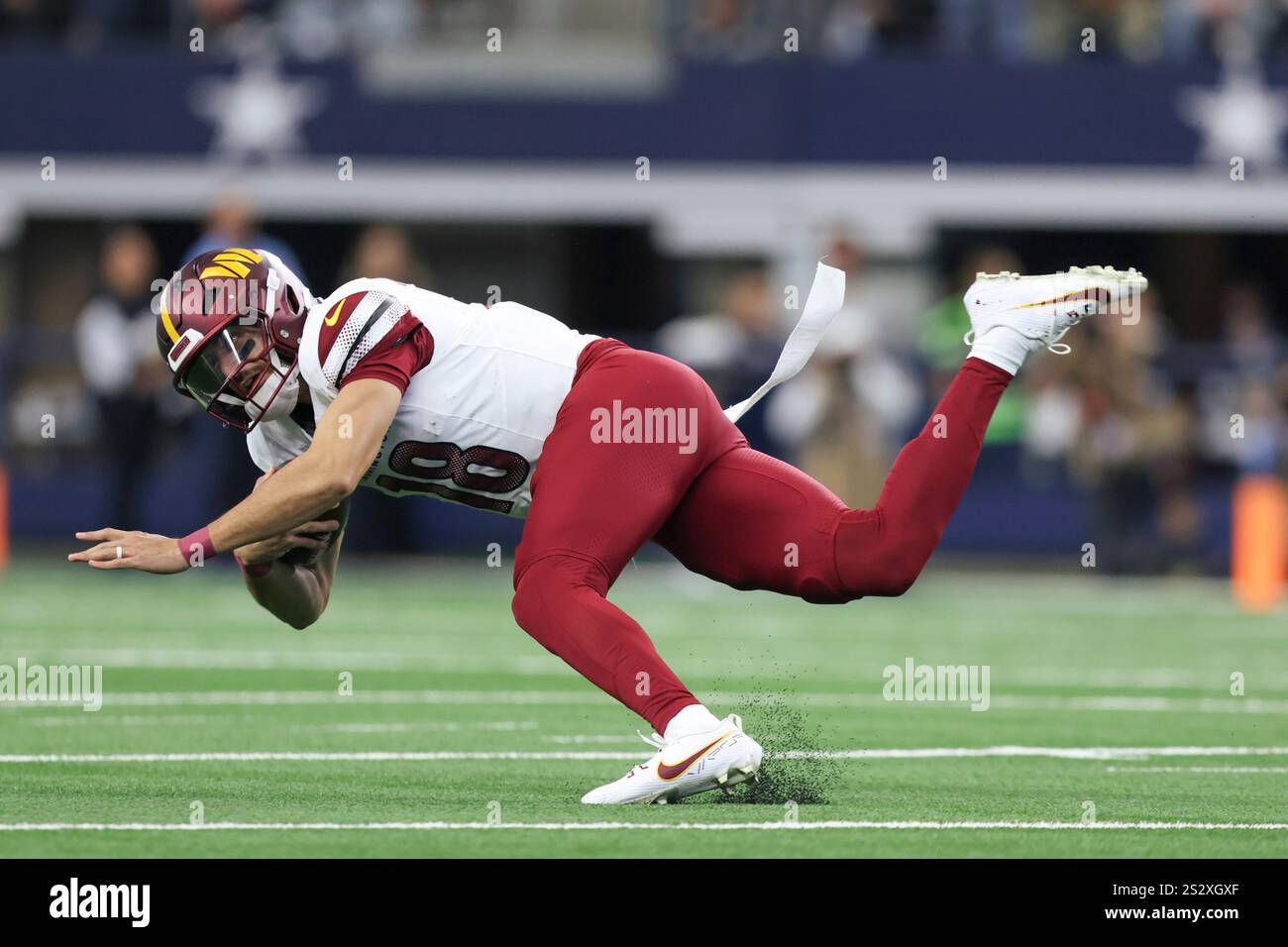 Washington Commanders quarterback Marcus Mariota falls as he rushes ...