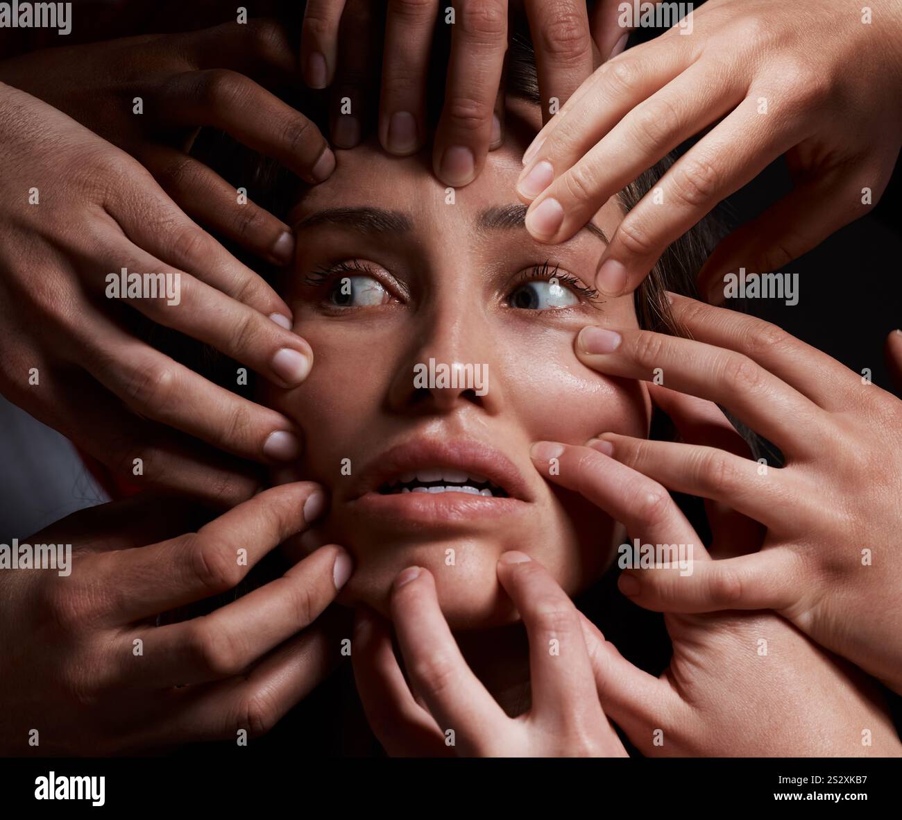 Hands, fear and schizophrenia with face of woman in studio for bipolar ...
