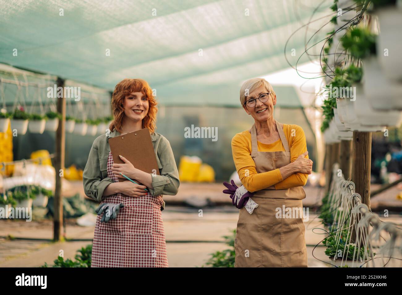 Portrait of two female botanists standing inside a vertical garden ...