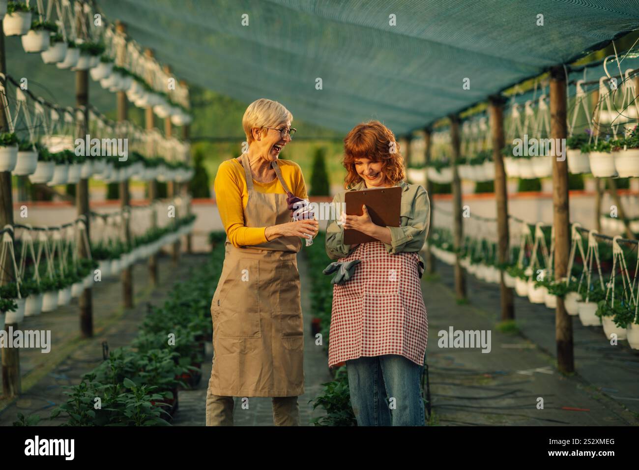 Two female horticulturalist enthusiasts laughing together while taking ...