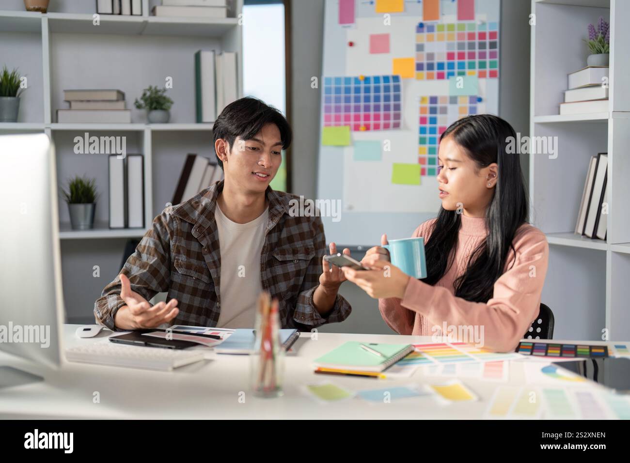 Design team meeting on color chart graphics in a creative workspace ...