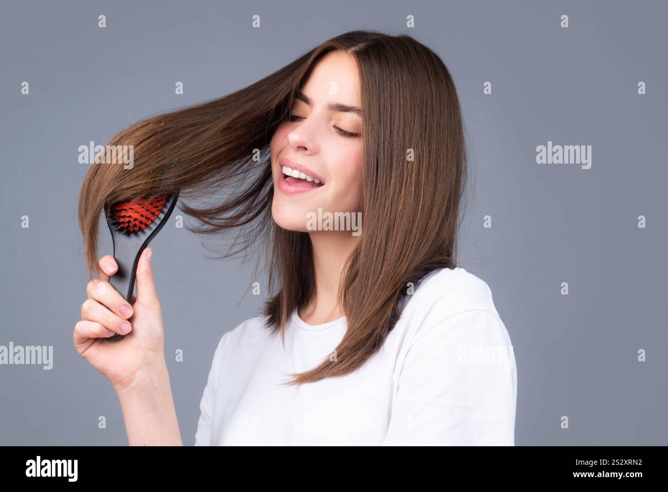 Beautiful woman combs her healthy hair. Combing healthy long straight ...