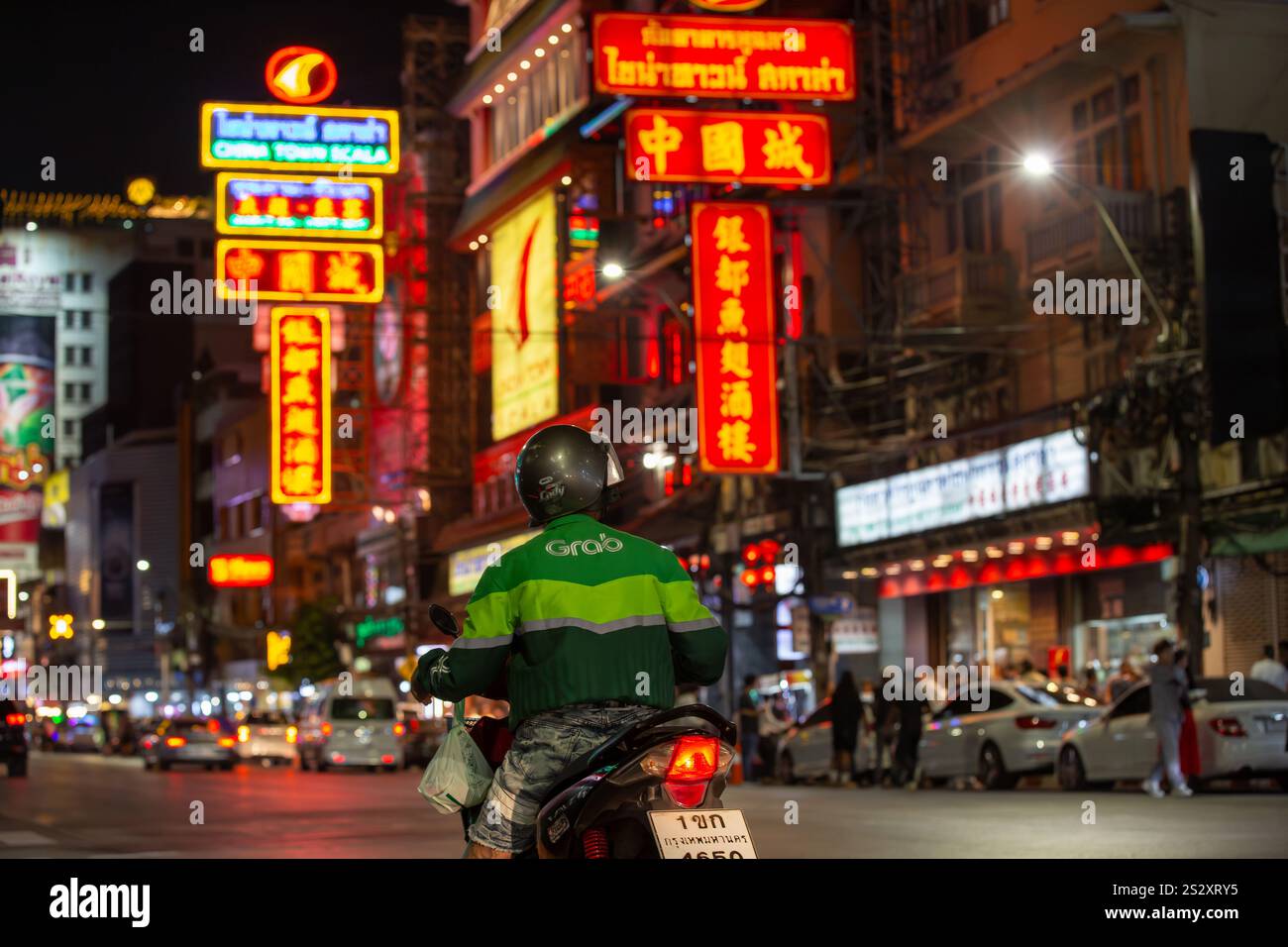 Bangkok, Thailand - January 06, 2025: GRAB delivery man on Yaowarat road, the main street of ...