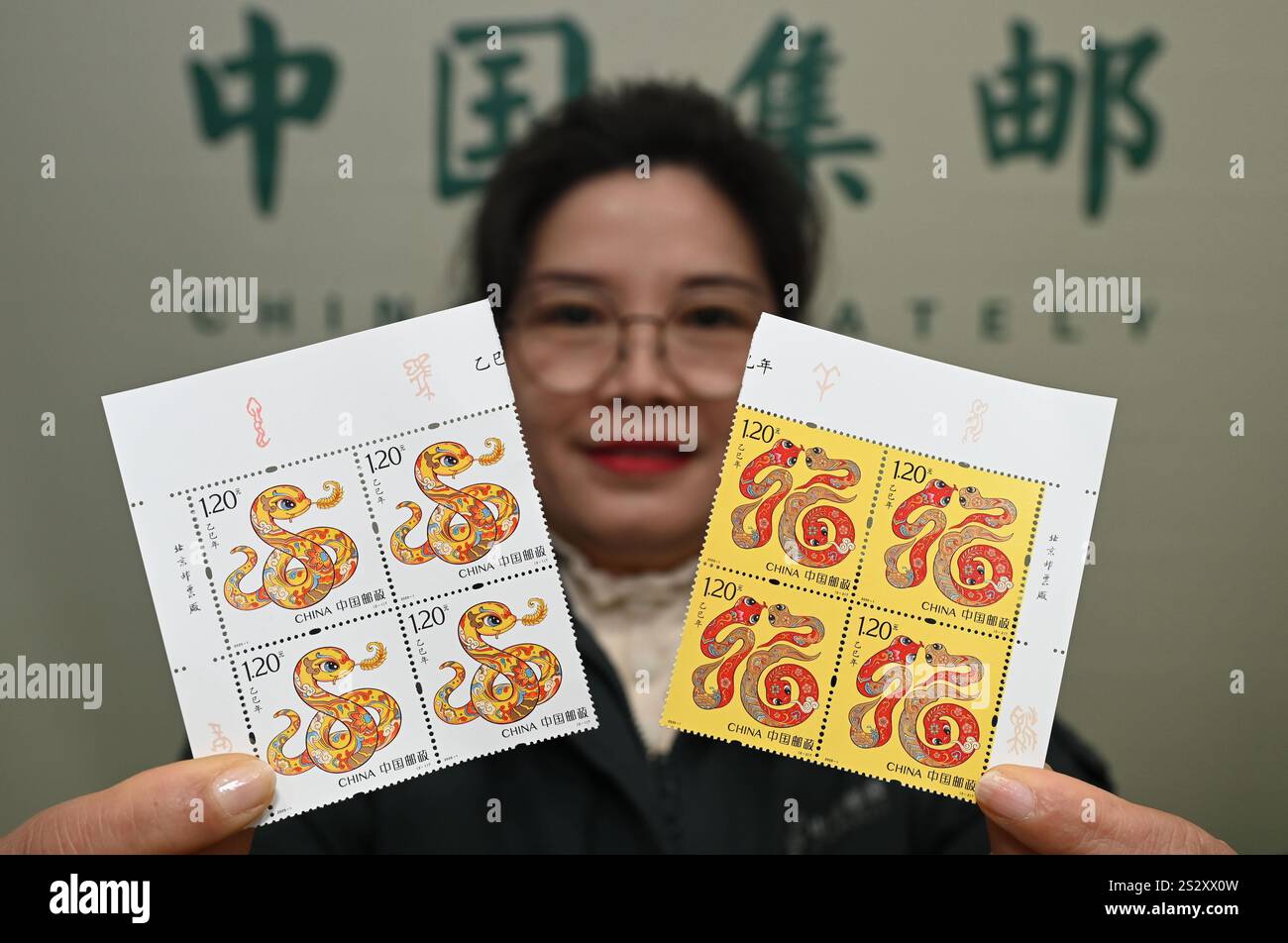 A staff member displays the special stamps marking the Chinese zodiac ...