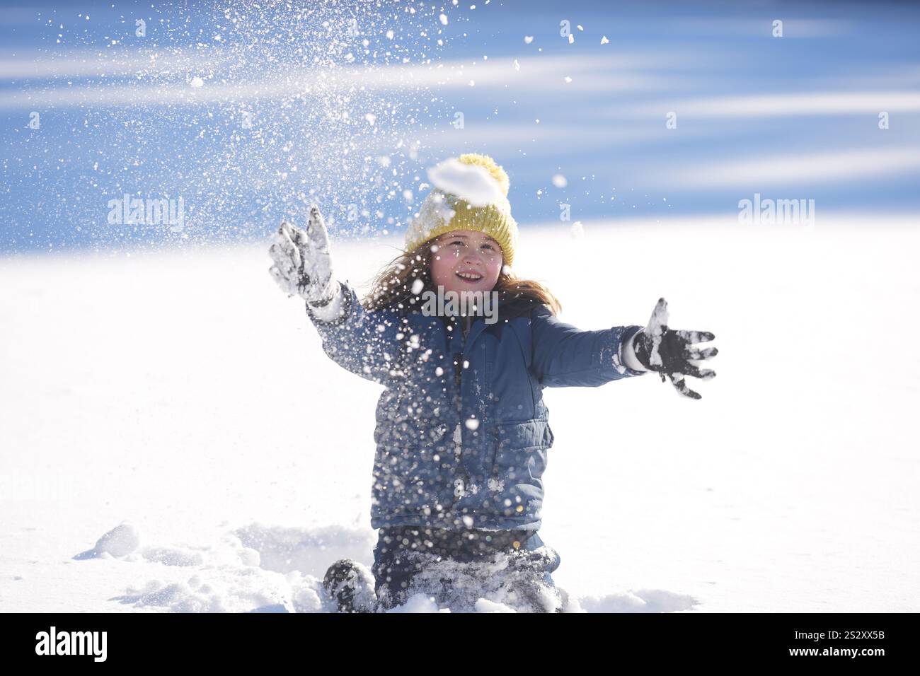 Kid boy play in the snow with a winter hat. Happy kid in warm clothes ...