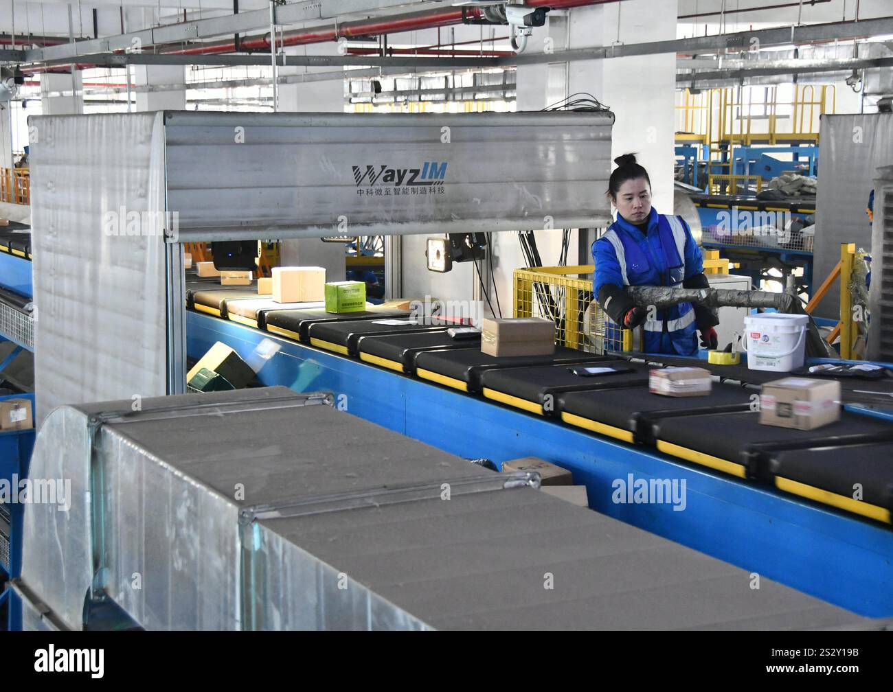 Workers sort deliveries at the ZTO Express transfer center in Yongnian ...