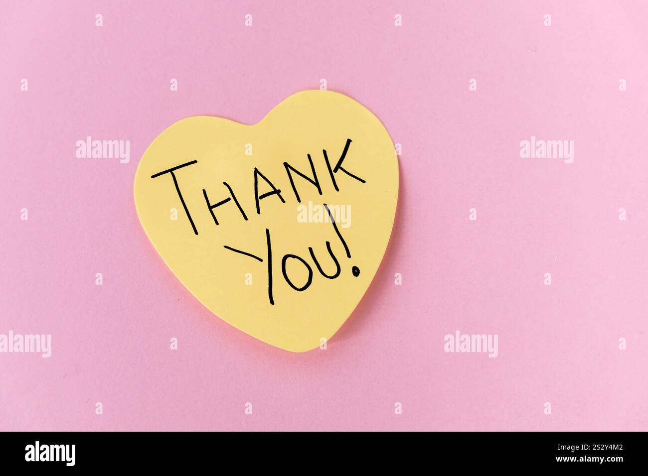 A single yellow, heart-shaped Post-It note with the handwritten message ...