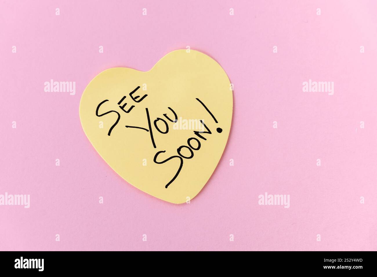 A single yellow, heart-shaped Post-It note with the handwritten message ...